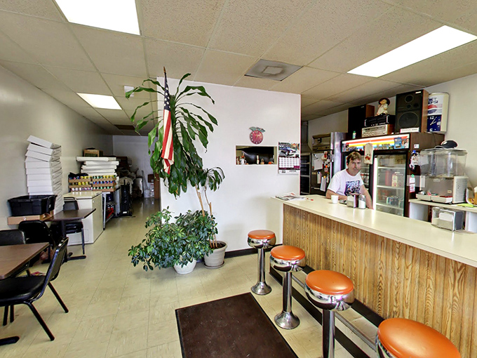 Inside, time stands still with vintage orange counter stools, wood paneling, and houseplants that have witnessed decades of donut-induced joy.