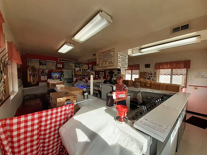 Inside the culinary time capsule: Red-checkered nostalgia meets mouth-watering aromas in this compact kitchen where magic happens daily.