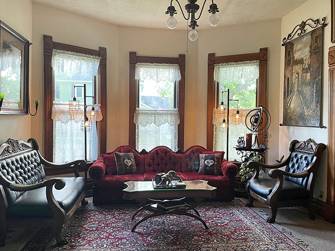 The parlor welcomes visitors with rich burgundy velvet and gleaming wood trim &ndash; Jules Verne would approve of this cozy time-travel portal.