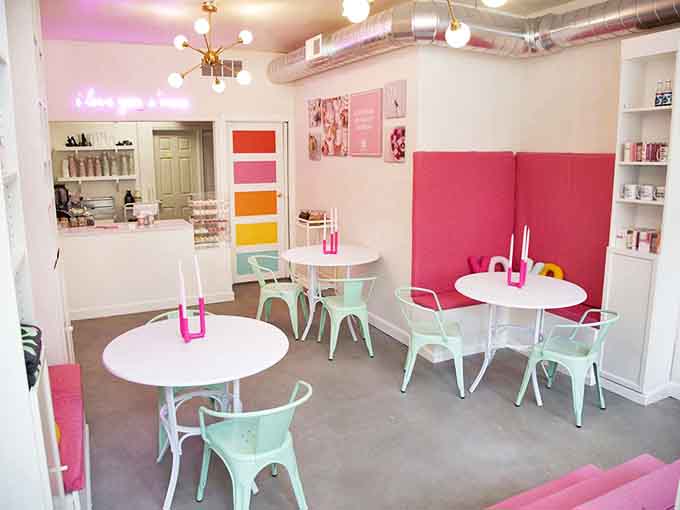 Pastel perfection awaits inside with mint chairs, white tables, and that irresistible neon sign declaring love in the sweetest possible way.