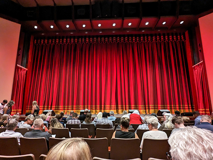 Rich crimson curtains frame the stage, ready to part and reveal worlds of wonder just as they have for generations of theatergoers.