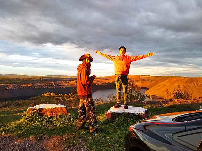 Visitors embrace the vastness of the Iron Range vista, arms outstretched as if trying to hug the entire landscape.