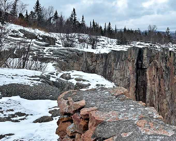 Winter transforms Palisade Head into a dramatic snow-covered fortress, where the stark cliff face meets Lake Superior's icy expanse.