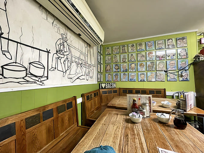 Green walls showcase caricatures of happy customers past, while the "I ❤️ BACON" sign speaks the universal language of good taste.