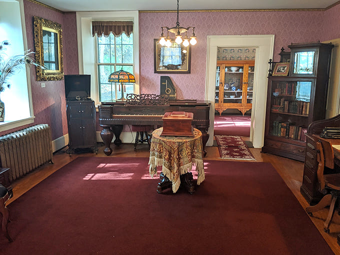 The parlor glows with Victorian charm, featuring a grand square piano and elegant decor from Stillwater&rsquo;s early pioneer days.