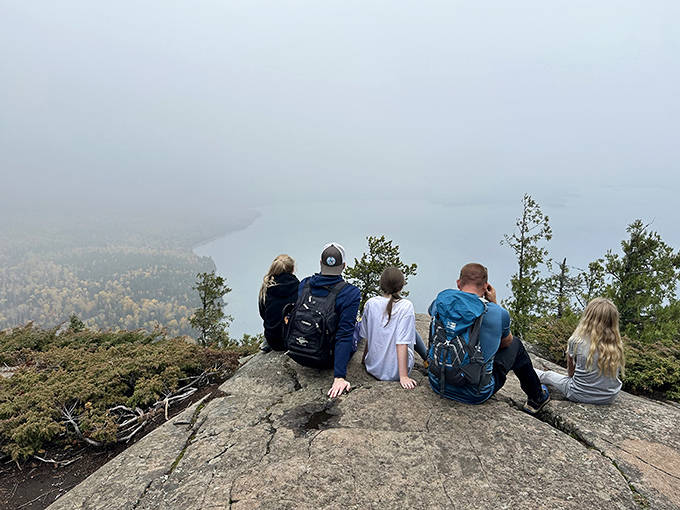Hikers perched on the edge of forever, where Lake Superior stretches to the horizon and everyday worries shrink to proper perspective.