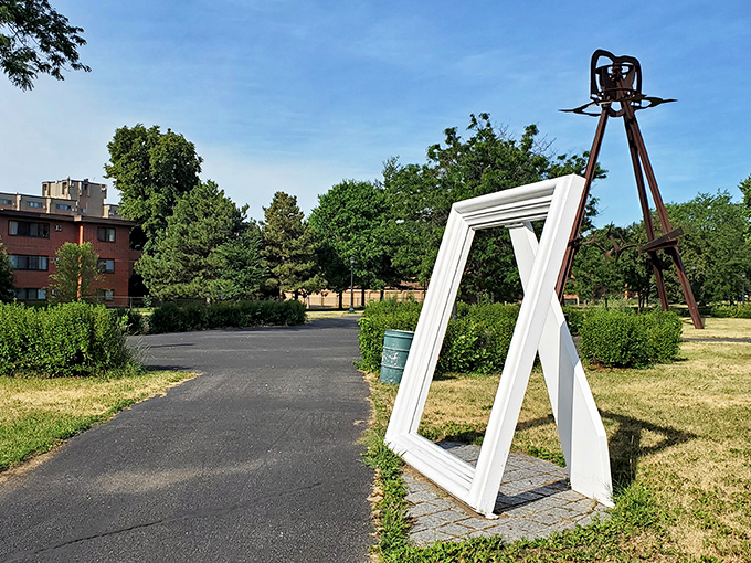 A stark white picture frame stands in Western Sculpture Park, turning everyday scenes into living art against the backdrop of industrial sculptures.