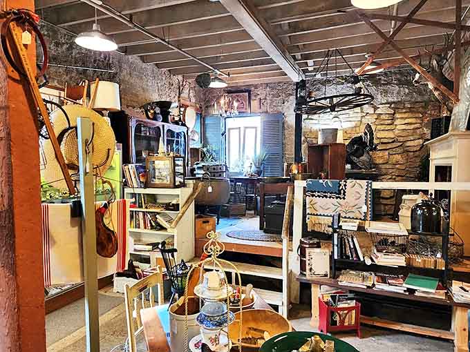 The rustic charm of exposed stone walls creates the perfect backdrop for antique hunting, with shelves and displays arranged to reward the patient explorer.