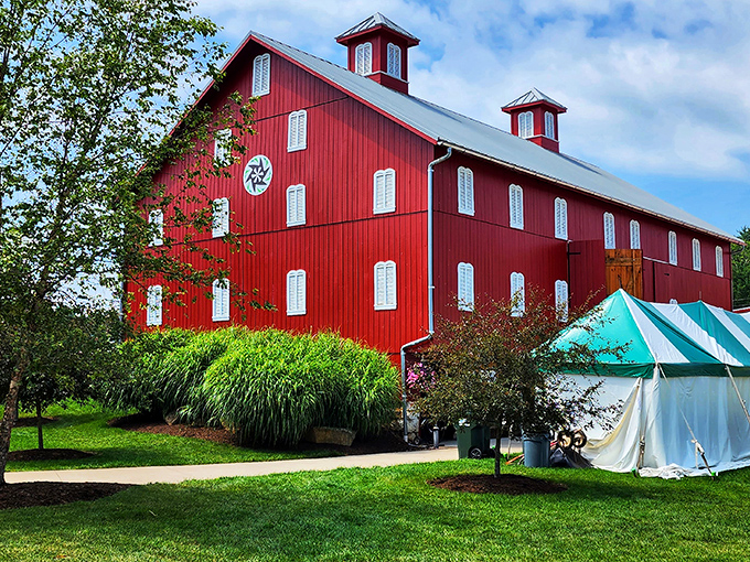 The vibrant red barn at Holmes County Fairgrounds stands proudly against blue skies, a testament to agricultural heritage.