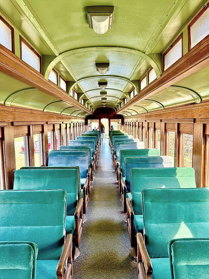 Vintage charm preserved in every detail &ndash; mint-green ceiling arches over polished wood and teal seats awaiting passengers' stories.