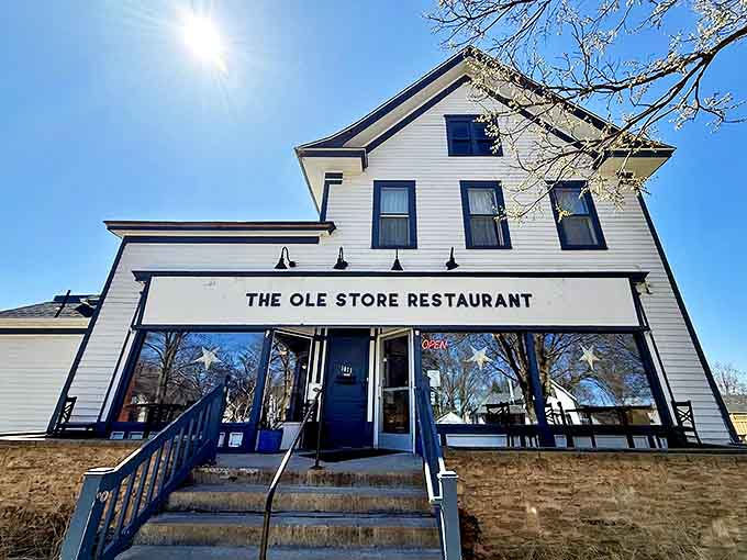The Ole Store Restaurant welcomes diners with its classic white clapboard exterior, promising farm-to-table delights inside this historic building.