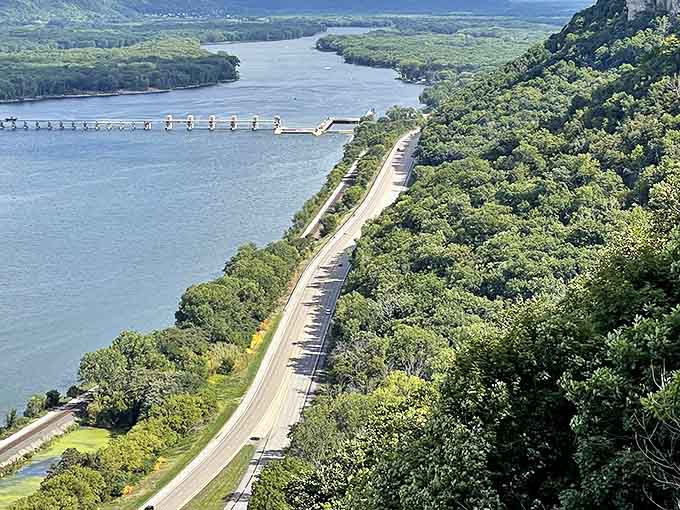 Highway 61 hugs the Mississippi's edge as seen from above, a ribbon of asphalt threading between water and wilderness.