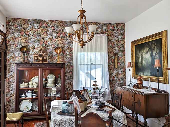The dining room's floral wallpaper and antique furnishings transport visitors to another era, where family gatherings included both the living and perhaps the departed.
