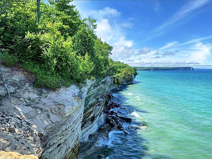 Towering sandstone cliffs stretch along Lake Superior's shoreline, their mineral-stained faces telling geological stories millions of years in the making.