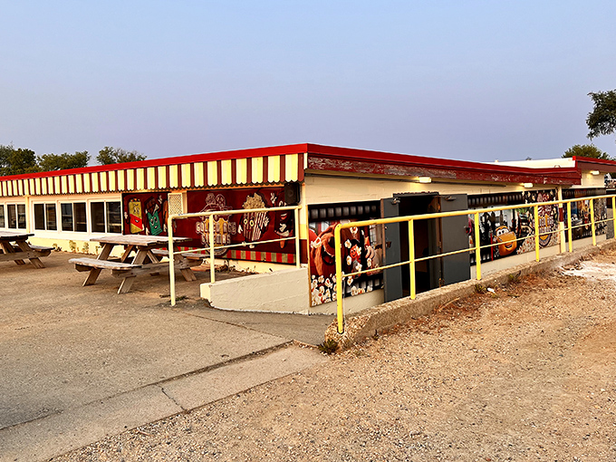 The iconic red and yellow striped snack bar stands ready to serve, a colorful beacon of concession delights.