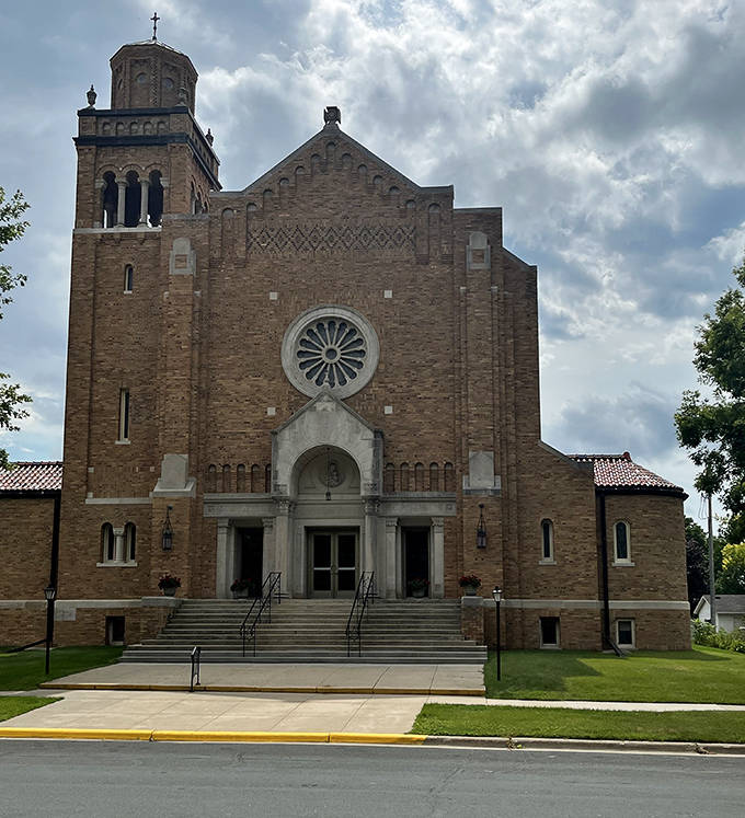Majestic stonework reaches skyward, its bell tower standing as both spiritual beacon and architectural marvel in Chatfield's historic landscape.
