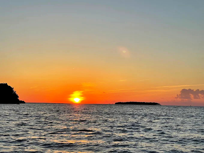 Mother Nature puts on a show as the sun dips below Lake Erie's horizon, painting the sky in warm hues of orange and gold.