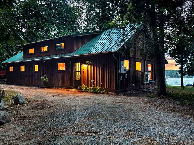 The Dragonfly Cottage glows with evening warmth, its wooden exterior practically whispering "come in and leave your troubles at the door."