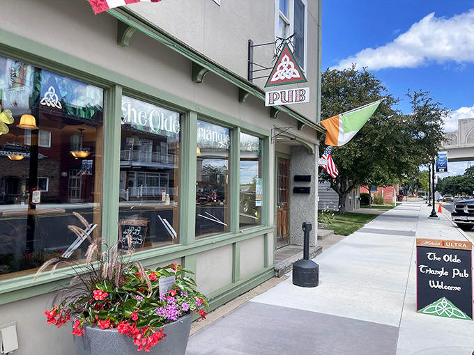 The Olde Triangle Pub's emerald facade and hanging flower baskets beckon passersby with promises of Irish hospitality and pints poured with practiced precision.