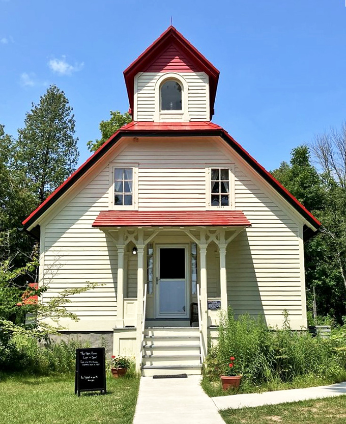 The charming white and red Range Light stands like a storybook cottage, its history etched in every weathered board and gleaming window.