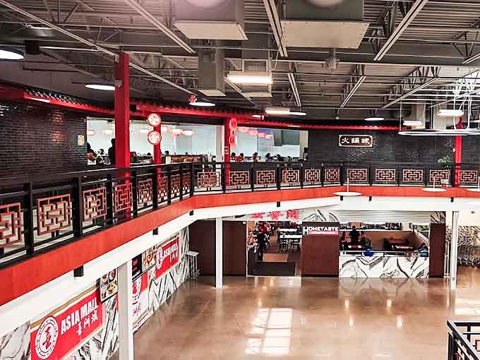 The upper level balcony offers a perfect vantage point to appreciate the mall's thoughtful design, with traditional red accents and geometric patterns throughout.