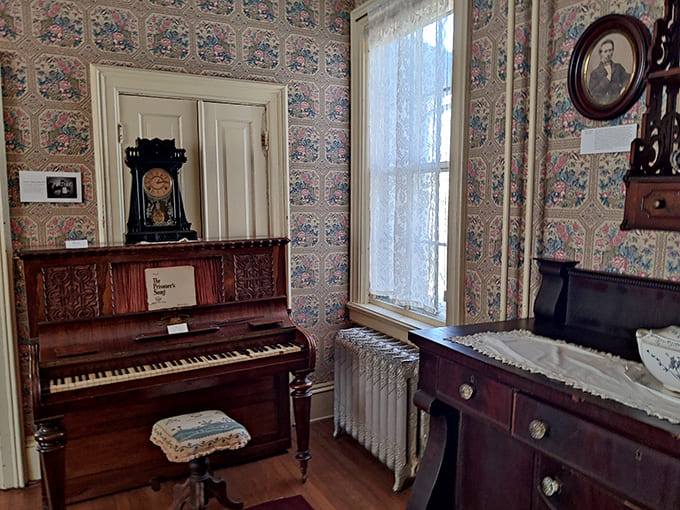 Music fills the air in this cozy nook, where a vintage upright piano stands against beautifully patterned period wallpaper.