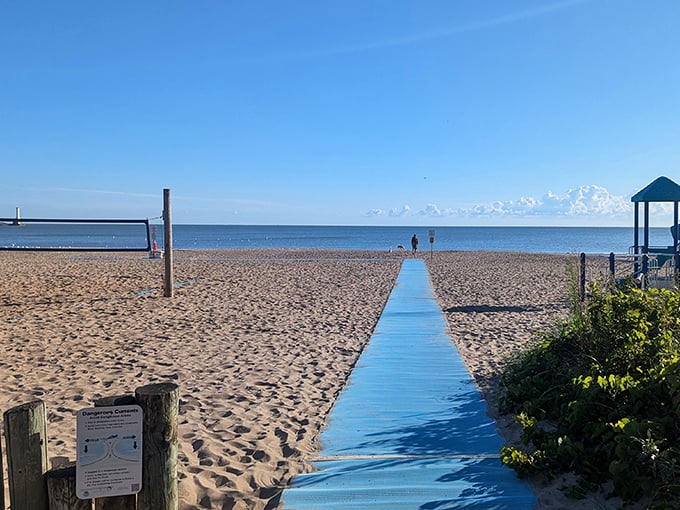 The welcoming blue boardwalk guides visitors to their sandy destination, building anticipation with every step.
