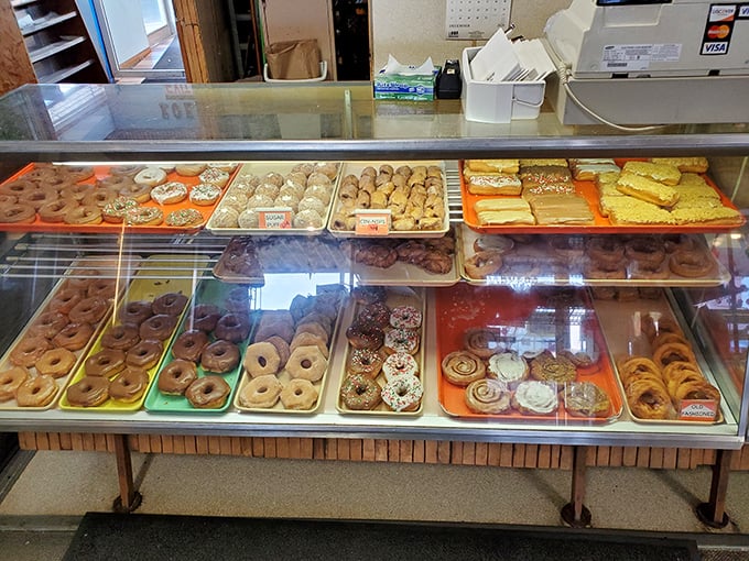 The display cases showcase an impressive array of donuts, pastries, and baked goods that would make even the most disciplined dieter weak at the knees.