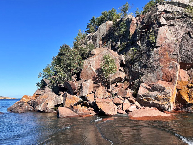 Rugged rock formations stand sentinel over the beach, their ancient faces telling geological stories to anyone patient enough to listen.