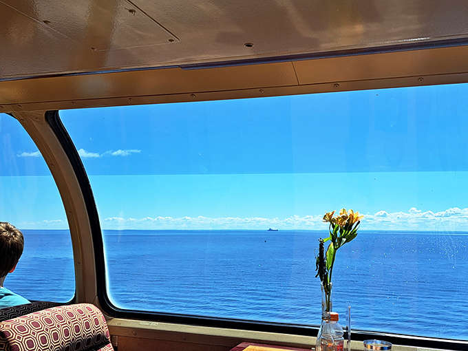 Nature's infinity pool meets sky at the horizon, while fresh flowers add a touch of elegance to this moving dining room.