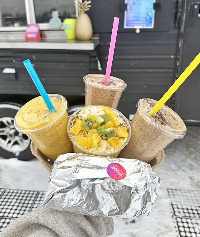 A trio of Shook's signature smoothies and a fruit-topped bowl create a rainbow of refreshment, perfect for a summer day in Grand Marais.