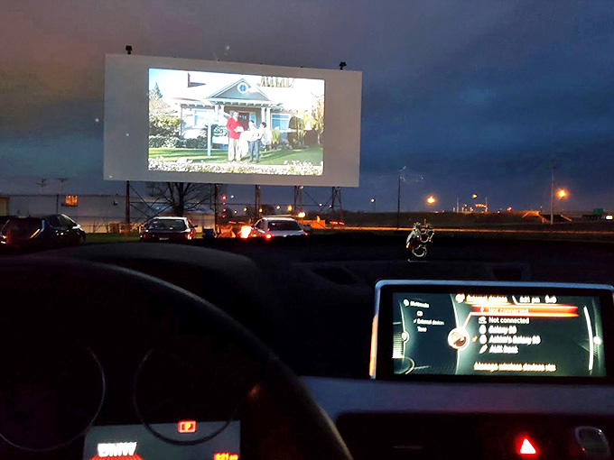 As darkness falls, the screen comes alive with images while viewers settle in for an evening of entertainment under the stars.