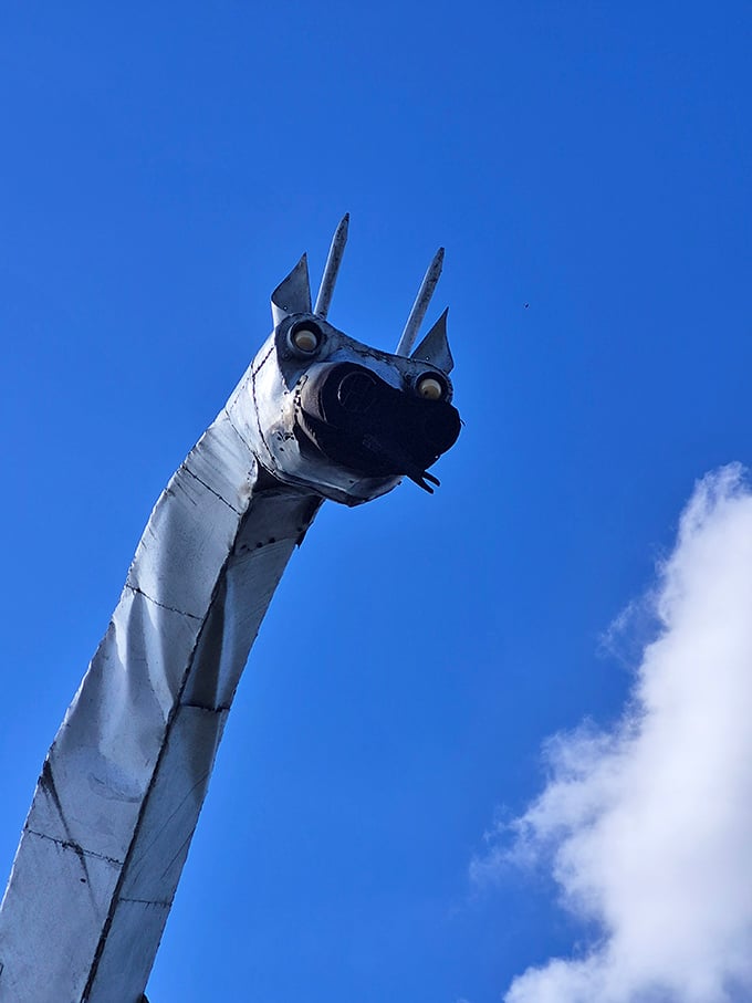 The dragon's head looms against a brilliant blue sky, its mechanical eyes seemingly watching for unsuspecting travelers to surprise with flames.