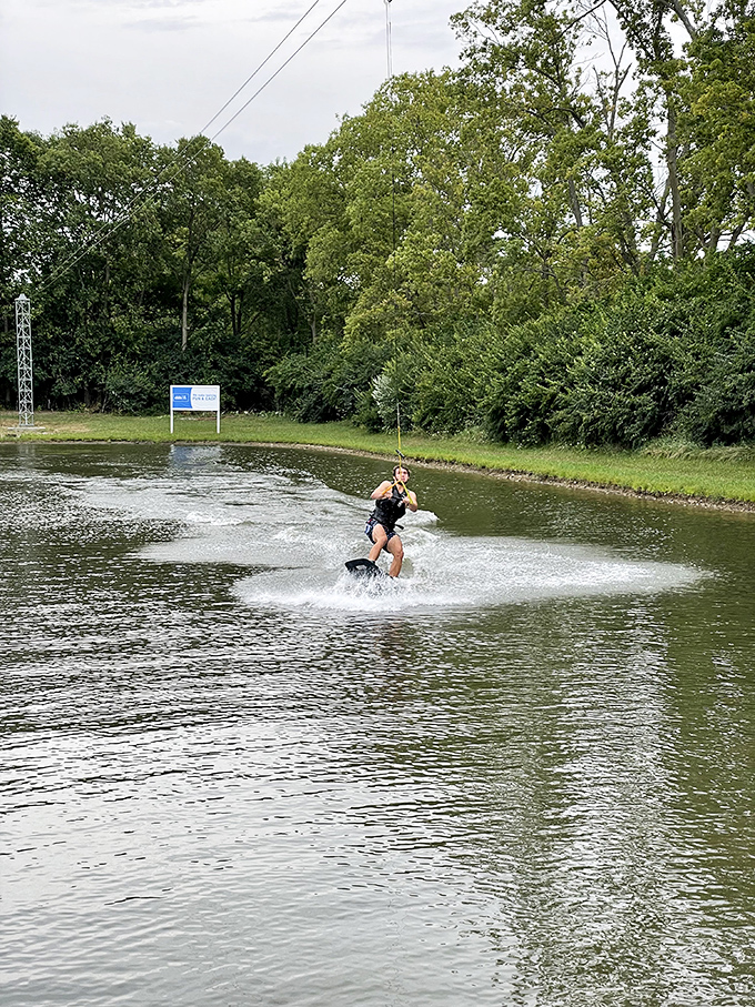 A wakeboarder carves through the water with surprising grace, making the rest of us weekend warriors question our life choices.