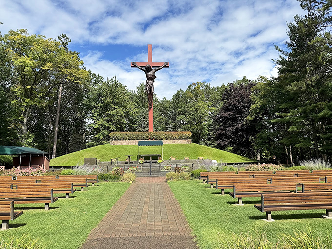 Standing tall against the Michigan sky, this impressive crucifix anchors the outdoor worship area where visitors contemplate both faith and fascinating doll collections.