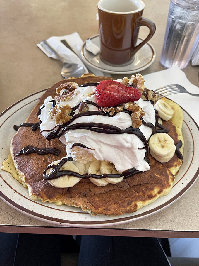 Banana split pancake heaven! Whipped cream mountains, chocolate drizzle rivers, and banana islands create a breakfast dessert paradise.