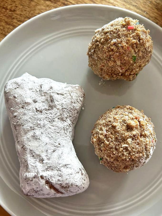 Sweet companions: a powdered beignet alongside cinnamon donut holes &ndash; proof that sometimes the simplest pleasures are the most profound.