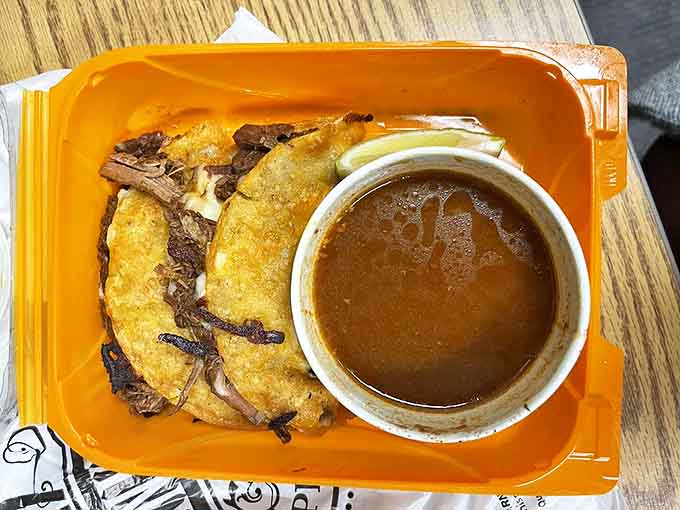 Birria tacos arrive with their sidekick consommé, a rich broth that transforms each bite into a flavor explosion worth the inevitable shirt stains.