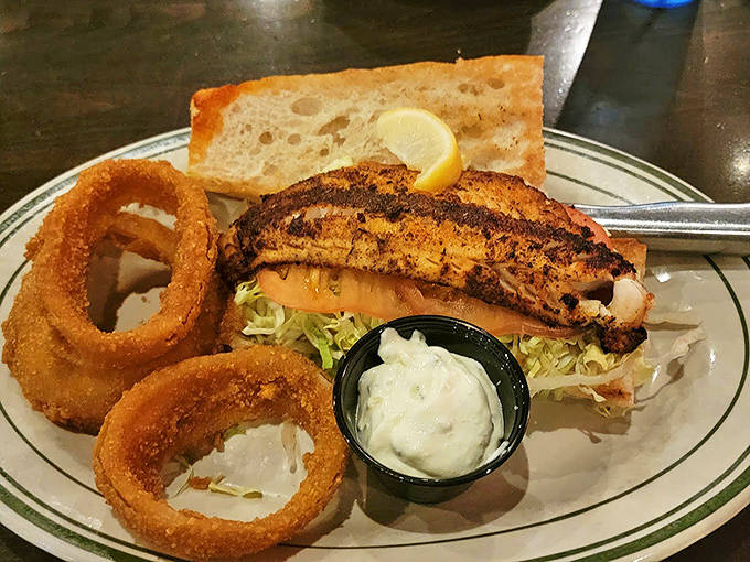 Blackened fish sandwich with golden onion rings &ndash; ocean meets crunch in a plate that would make any seafood lover swoon.