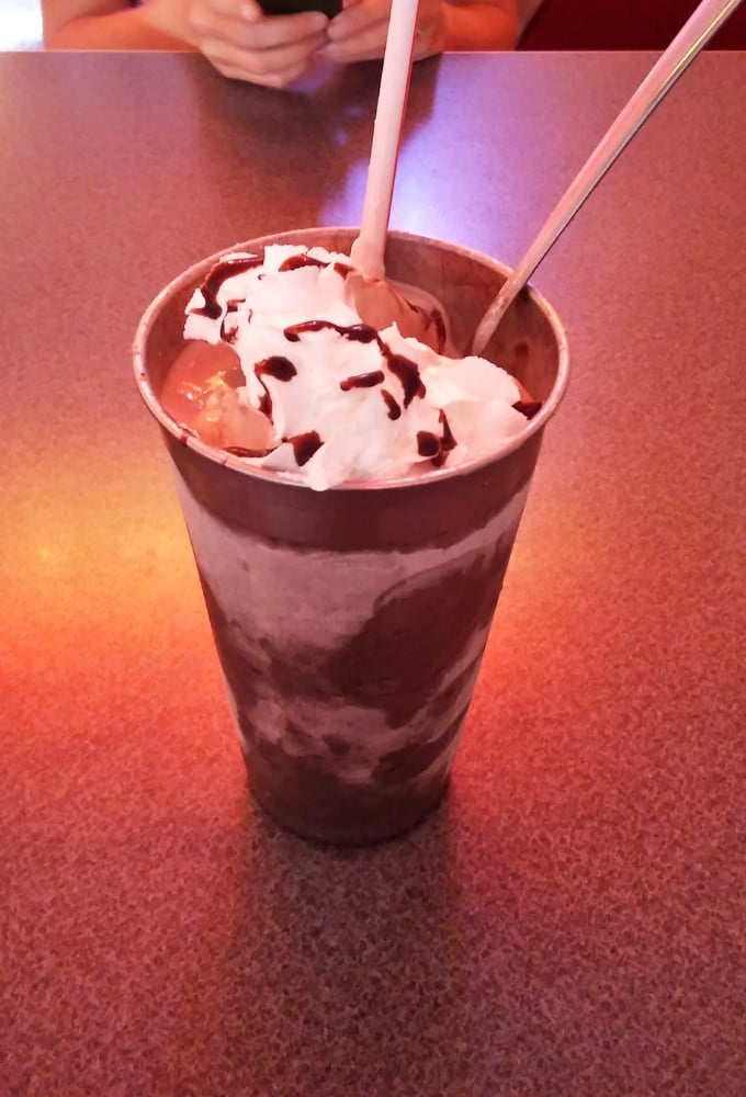 The chocolate milkshake arrives with both straw and spoon &ndash; a silent acknowledgment that drinking dessert is a two-tool job worth every calorie.
