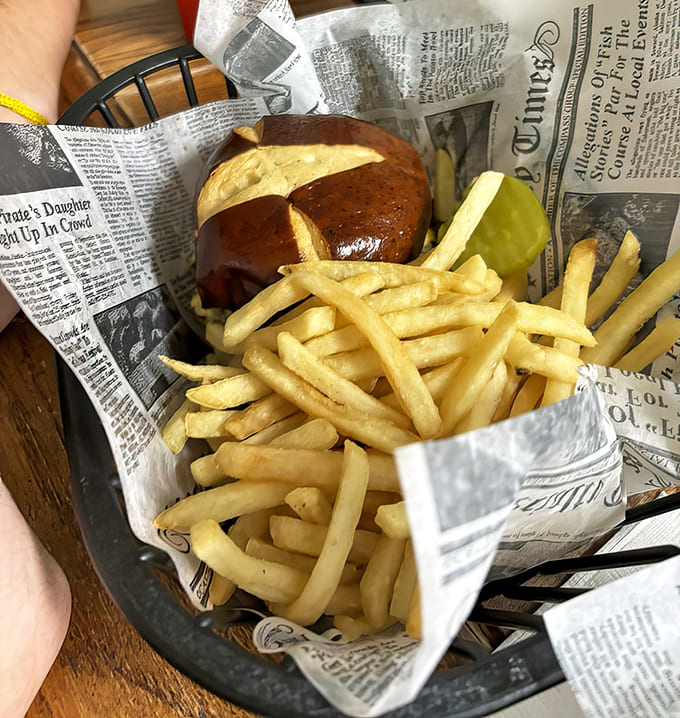 A perfect pretzel bun cradles the burger while golden fries stand at attention. This isn't fast food; it's slow food done right.