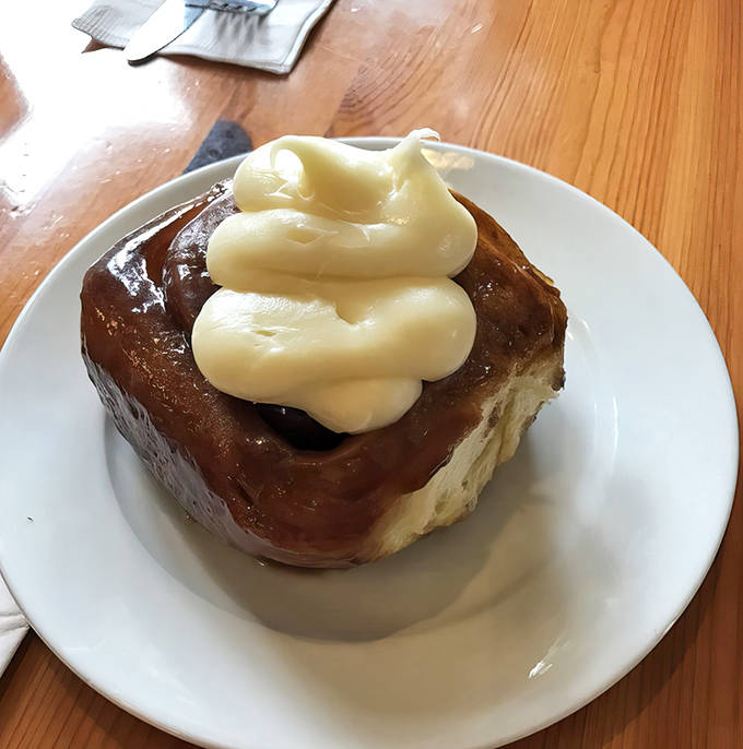 This isn't just a cinnamon roll &ndash; it's an architectural marvel of pastry engineering, crowned with cream cheese frosting that cascades down in glorious rivulets.
