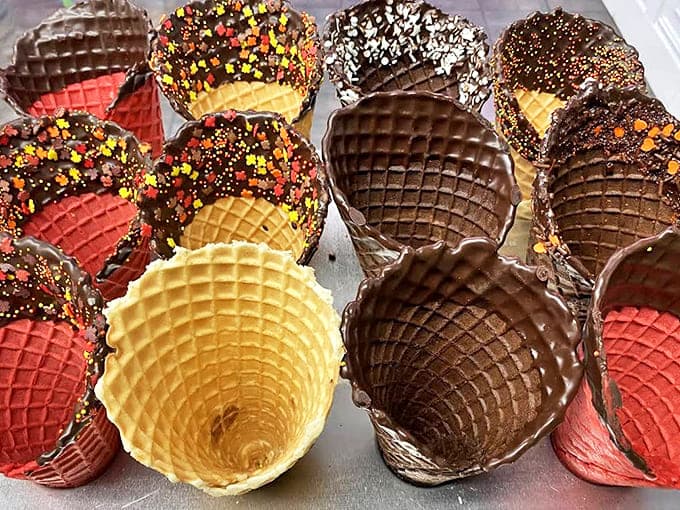 These aren't just waffle cones; they're architectural marvels with chocolate-dipped rims and sprinkle crowns fit for royalty.