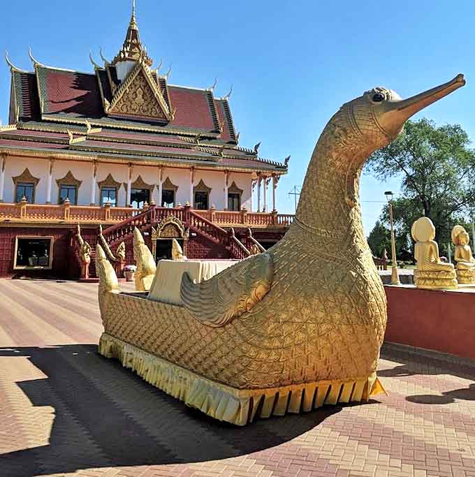 A golden hamsa bird statue guards the temple courtyard, its mythical presence a reminder that you've wandered into a pocket of Cambodia in America's heartland.