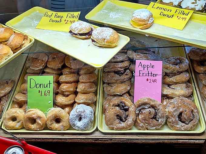 Glazed donuts and apple fritters glisten under bakery lights, each one a testament to the simple perfection of traditional Amish baking techniques.