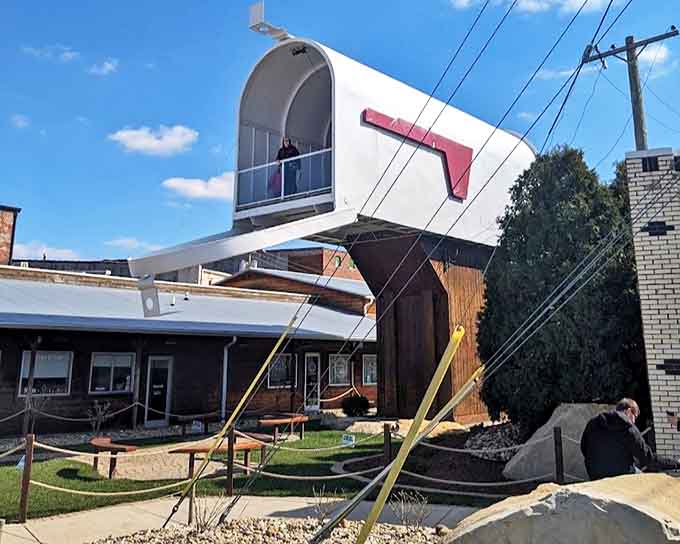 Looking up with childlike wonder at Casey's colossal creation. The mailbox towers above visitors like a postal monument to small-town imagination.