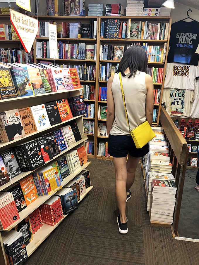 A browser explores the fiction section, where bestsellers mingle with classics in a democratic celebration of storytelling across generations.