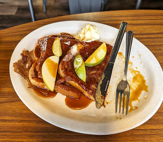 This isn't your ordinary French toast &ndash; thick-cut sourdough adorned with fresh apple slices and homemade caramel sauce creates a breakfast masterpiece. 