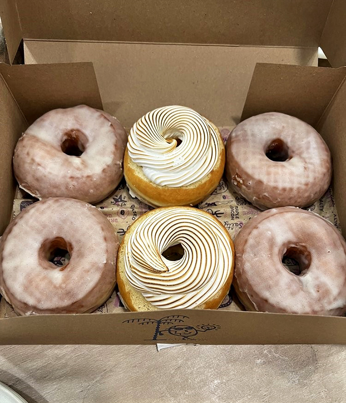 Box of joy! Classic glazed donuts share space with meringue-topped creations &ndash; proof that sometimes the simplest pleasures are the most satisfying.