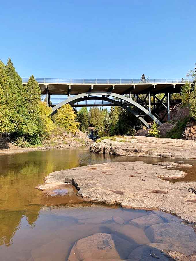 The graceful arch of Gooseberry Falls' highway bridge frames the rushing waters below like a postcard come to life.